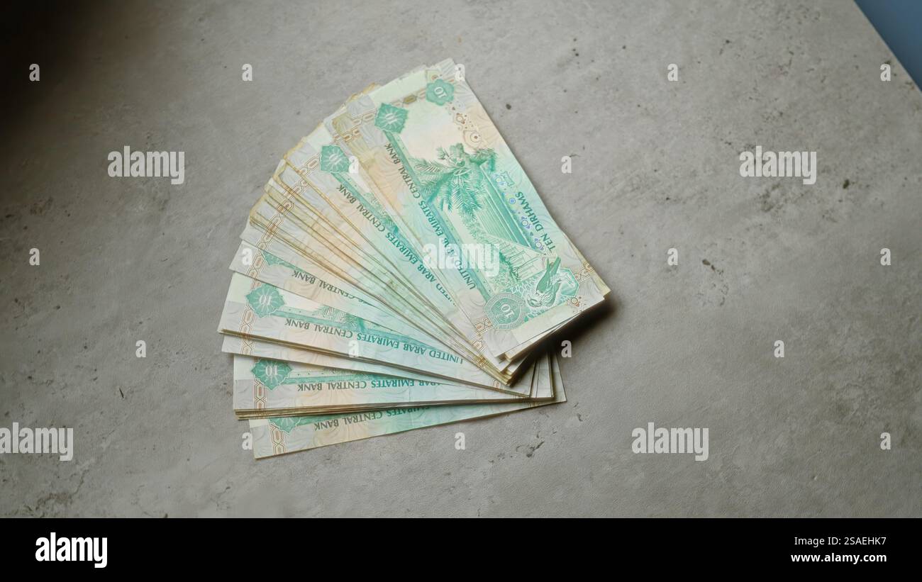 Uae dirham banknotes fanned out on a concrete surface showcasing united ...