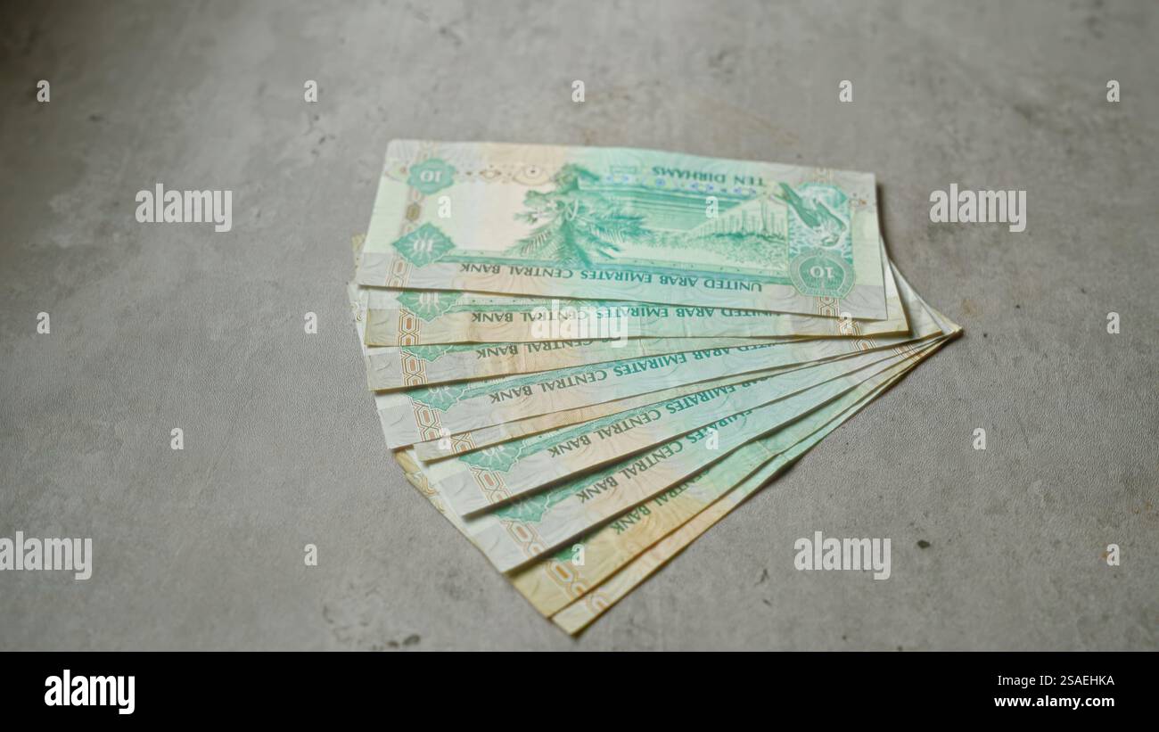 United arab emirates dirhams fanned out on a concrete surface ...