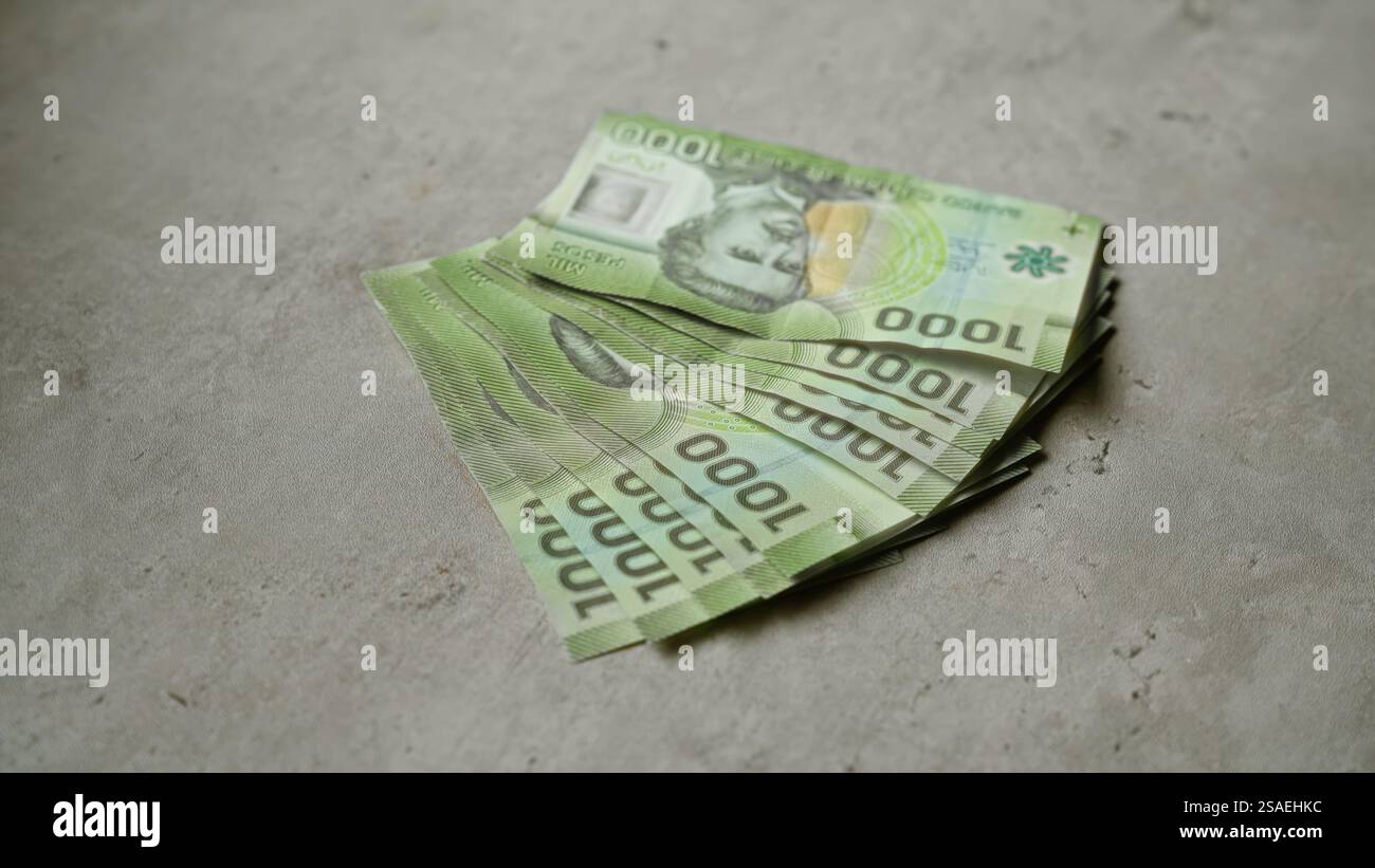Chilean banknotes in denominations of 1000 pesos placed on a concrete ...