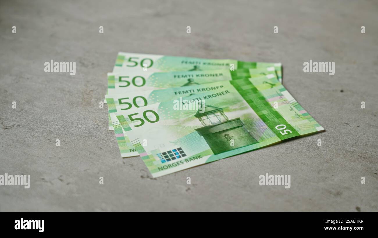 Norwegian banknotes, fifty kroner, arranged on a concrete surface ...