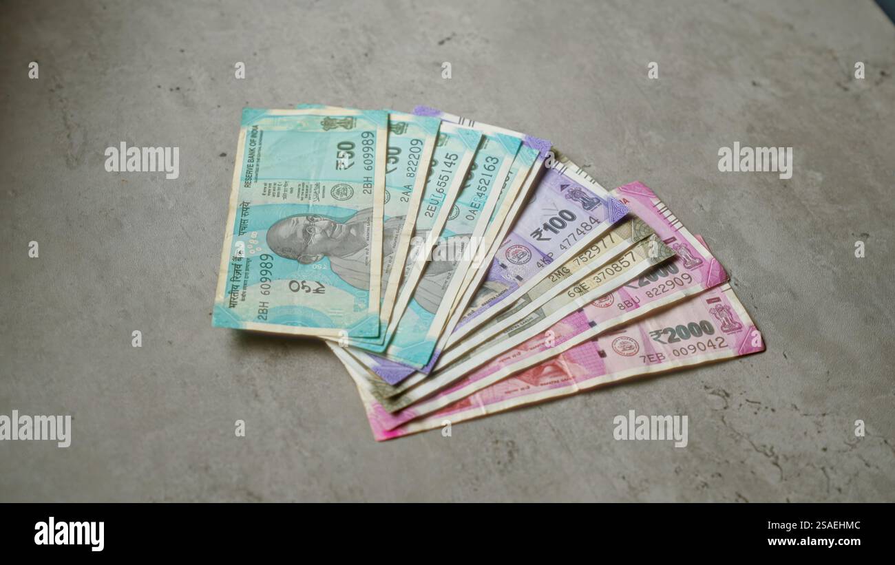 Indian rupees arranged in a fan shape laid out on a concrete surface ...
