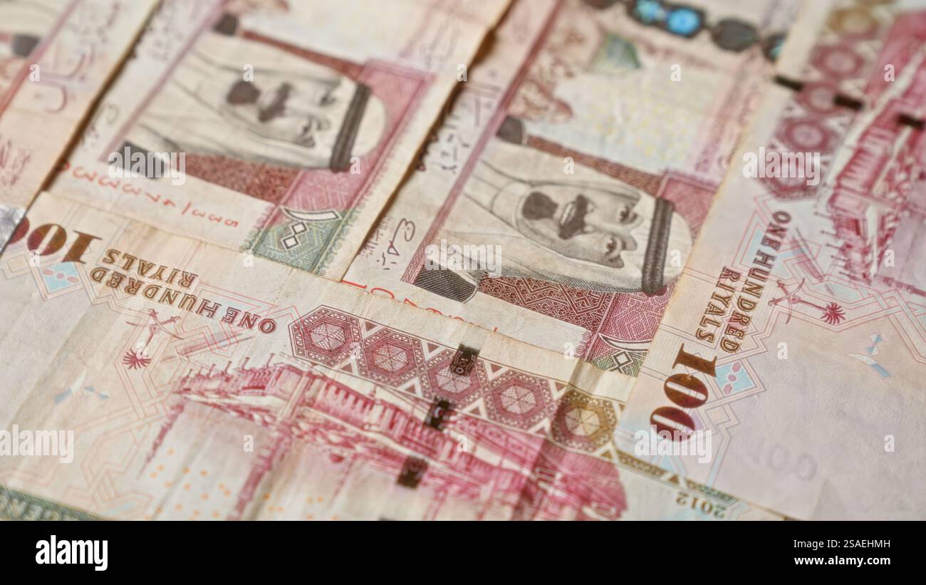 Saudi arabian banknotes in denominations of 100 riyals are closely ...