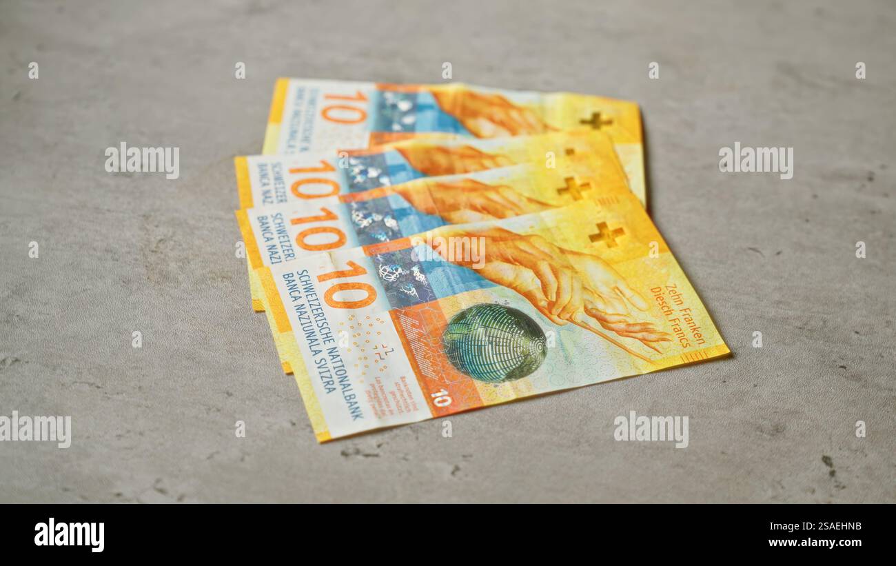 Swiss banknotes displaying 10 franc denominations placed on a concrete ...