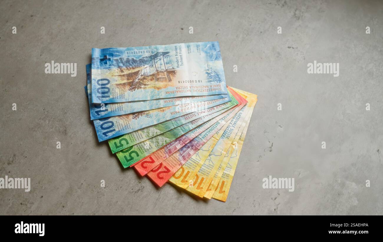 Swiss franc banknotes arranged on a concrete surface showcase the ...