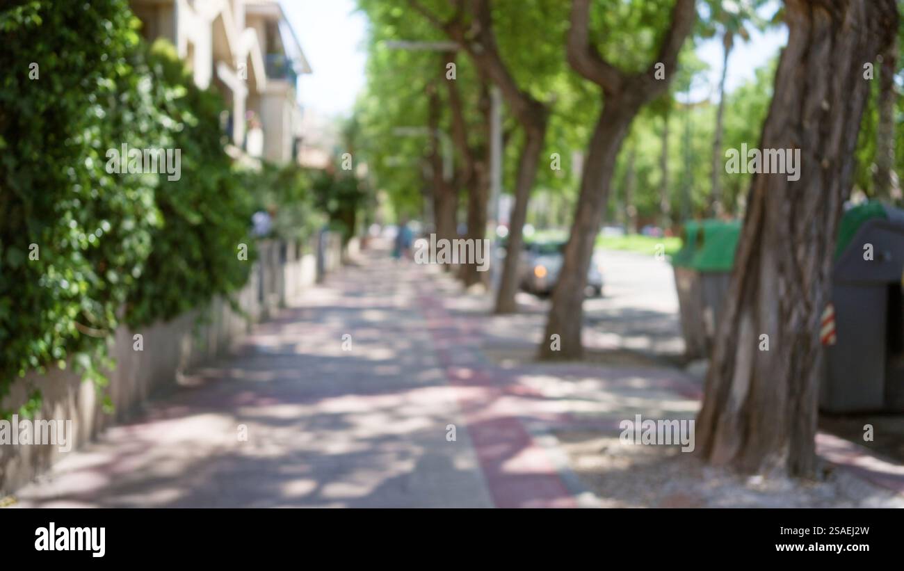 Blurred image of an outdoor street scene with trees, cars, and houses ...