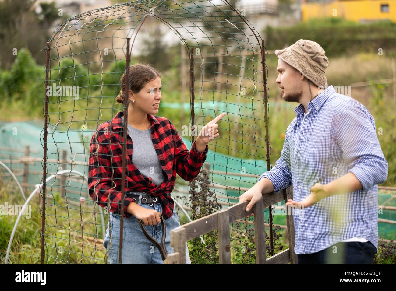 Angry girl quarreling with male neighbor, talking through fence Stock Photo - Alamy