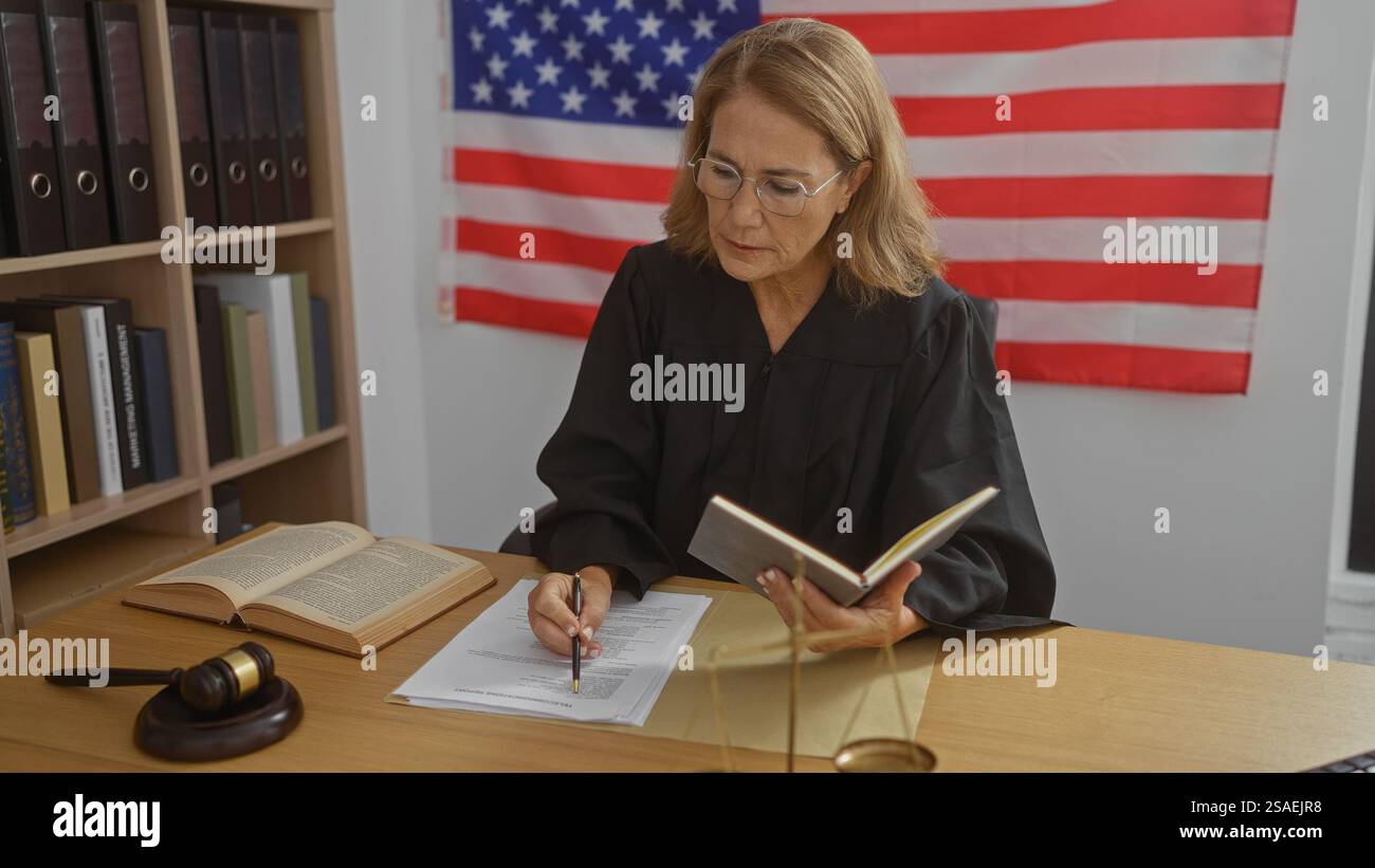 Female judge reading book at desk with gavel and american flag in ...