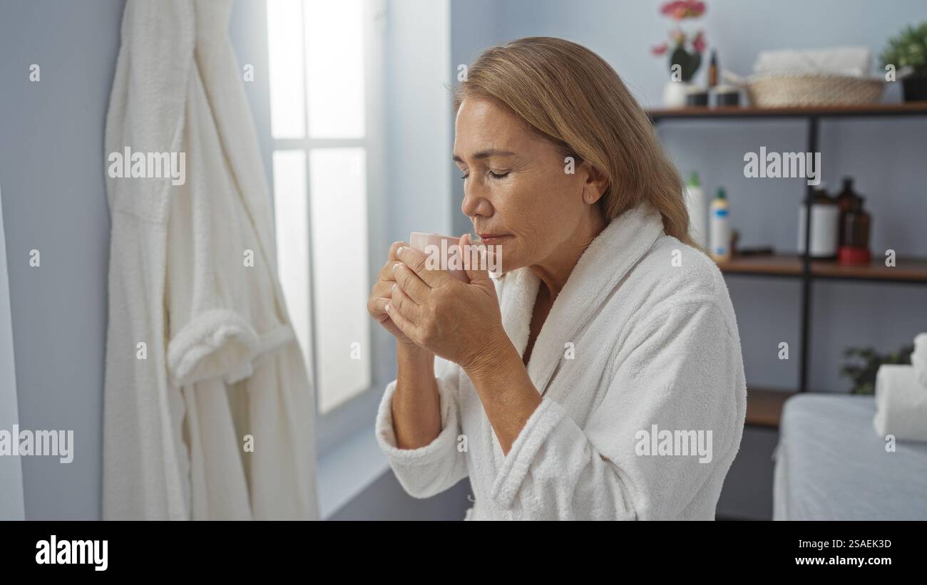 Mature woman enjoying a hot beverage in a serene spa setting, wearing a ...