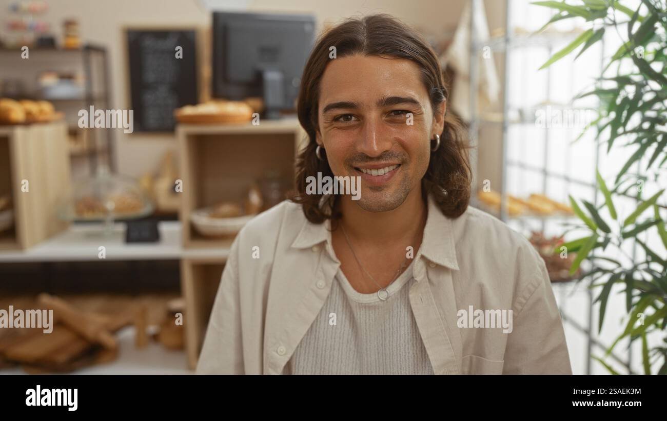 Young hispanic man smiling in a cozy bakery shop interior filled with ...