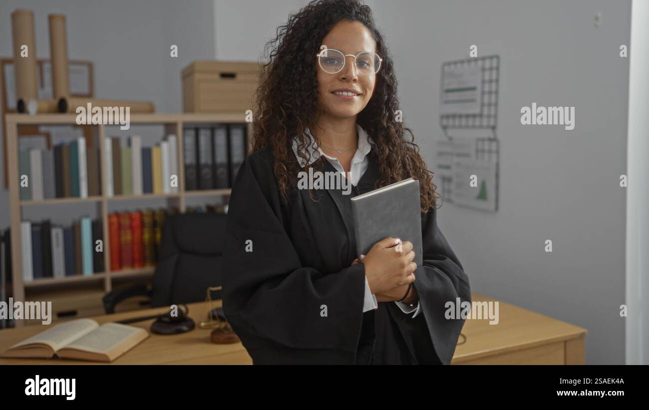 Young woman in judge robe standing in office holding notebook with ...
