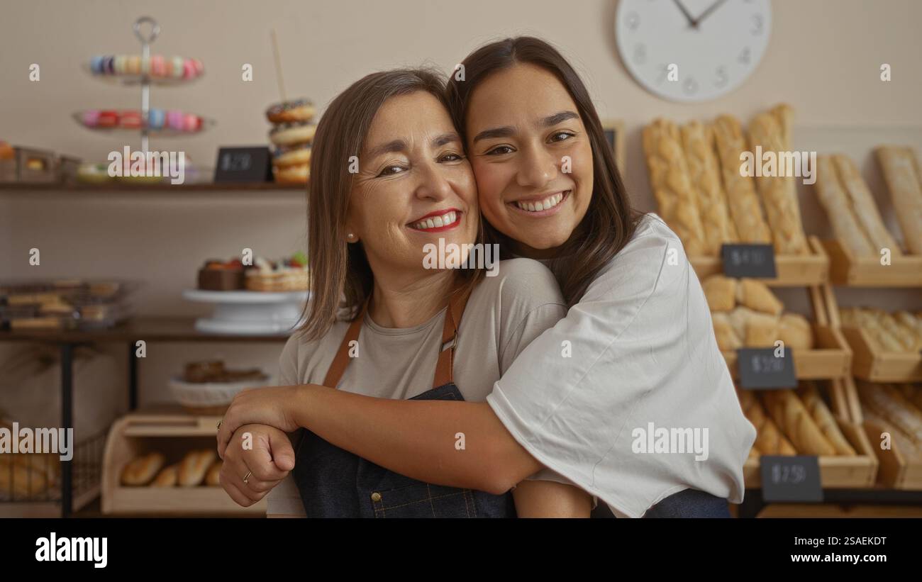 Two smiling women, adult bakers, hugging together in a cozy bakery shop ...
