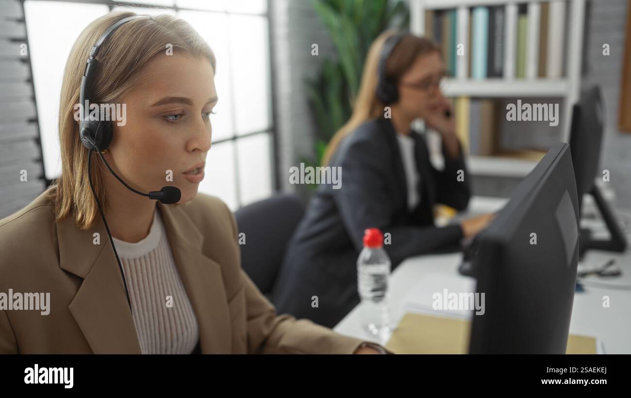 Businesswomen using headsets working at computers in a modern office ...
