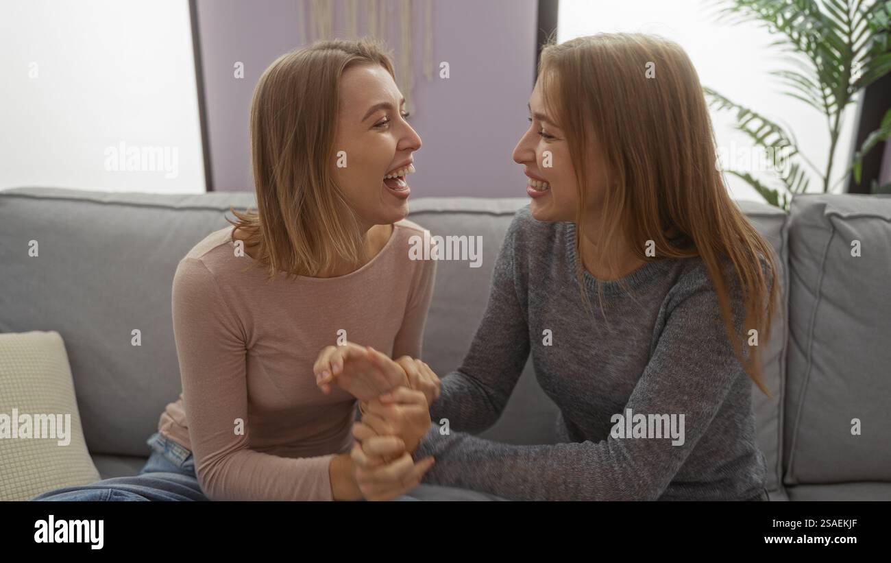 Sisters laughing together in a cozy living room, highlighting family ...