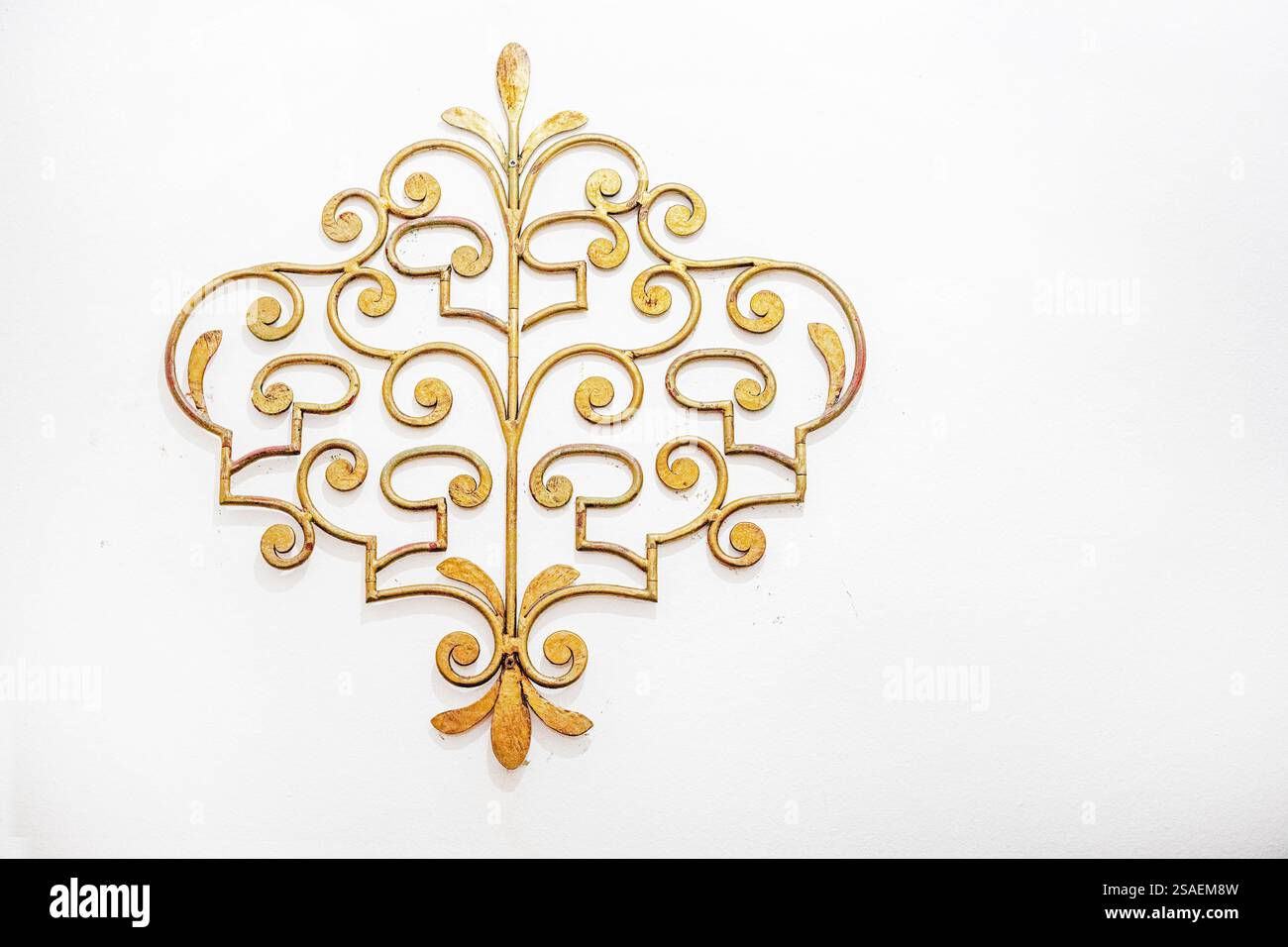 gold ornamental plant forging on a light background Stock Photo - Alamy