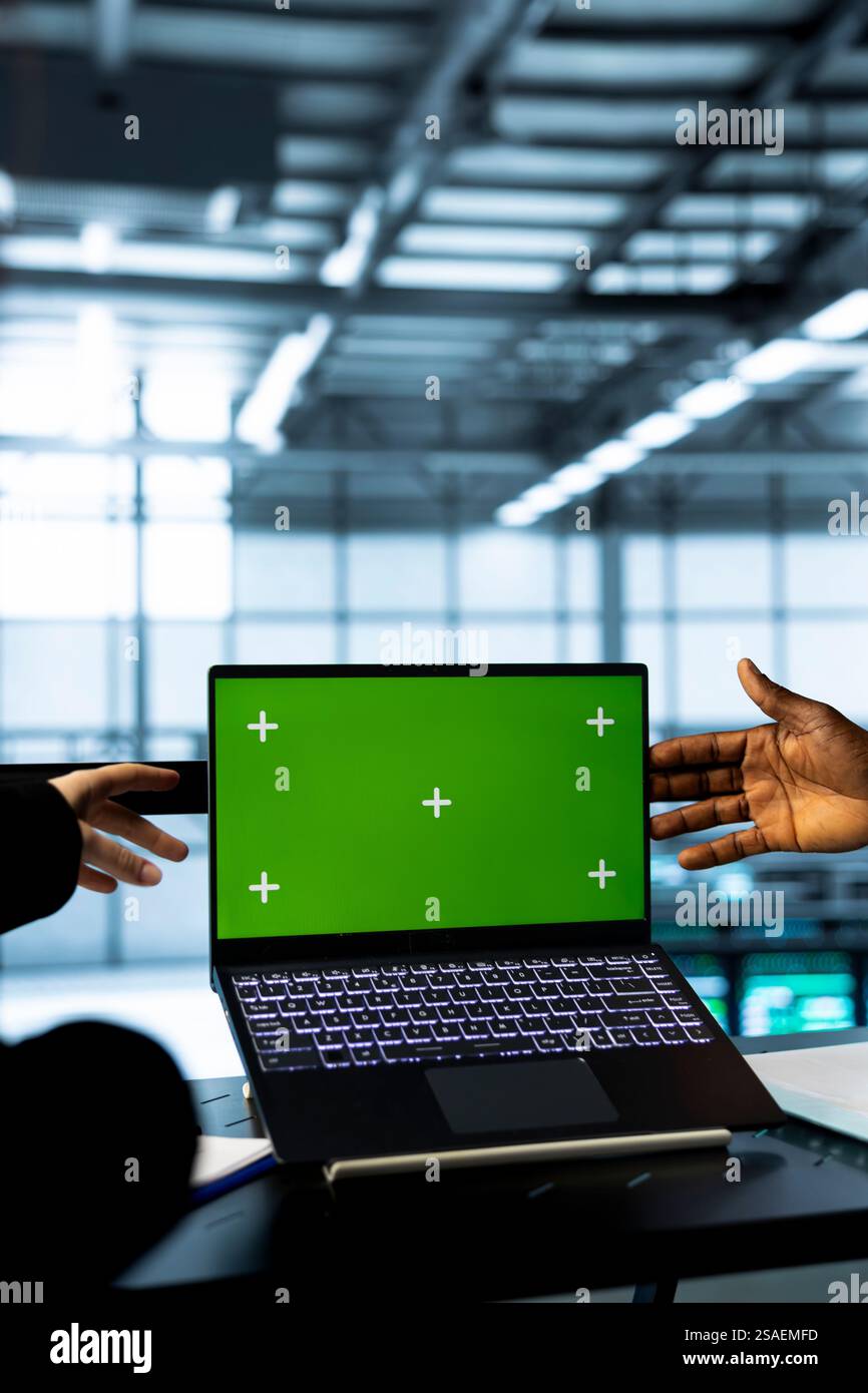 Computer scientists in data center using green screen notebook, observing analytics, reviewing ...