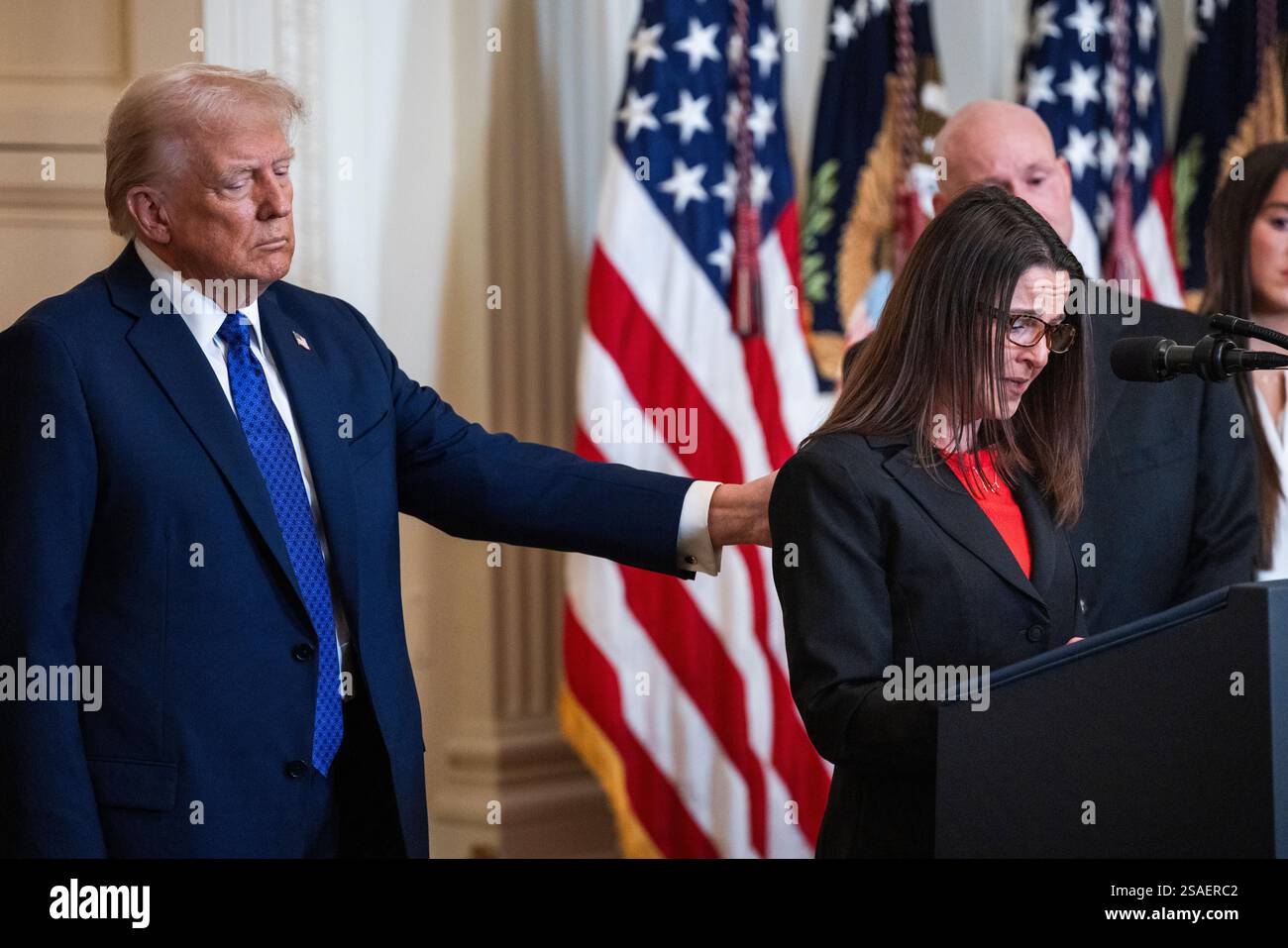 United States President Donald Trump (L) comforts Allyson Phillips (R ...