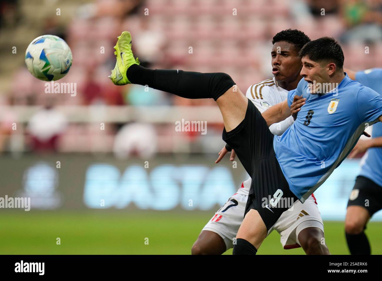 Uruguay's Renzo Machado, front, controls the ball challenged by Peru's ...