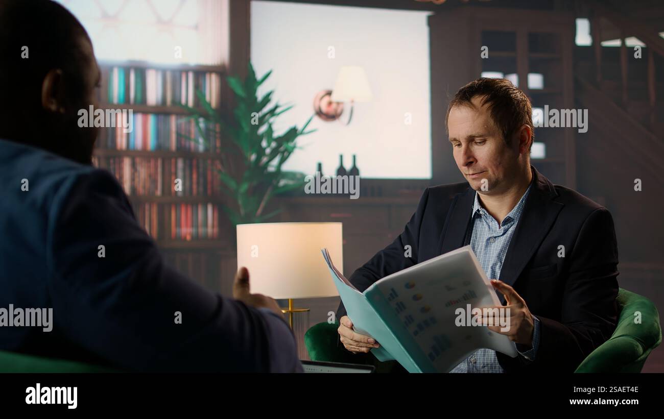 Diverse secret service duo in a CIA library lounge reviewing strategic ...