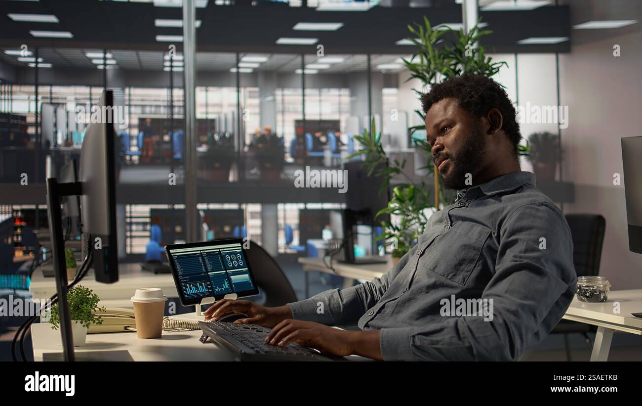 African american employee stretching his arms and back muscles at the ...