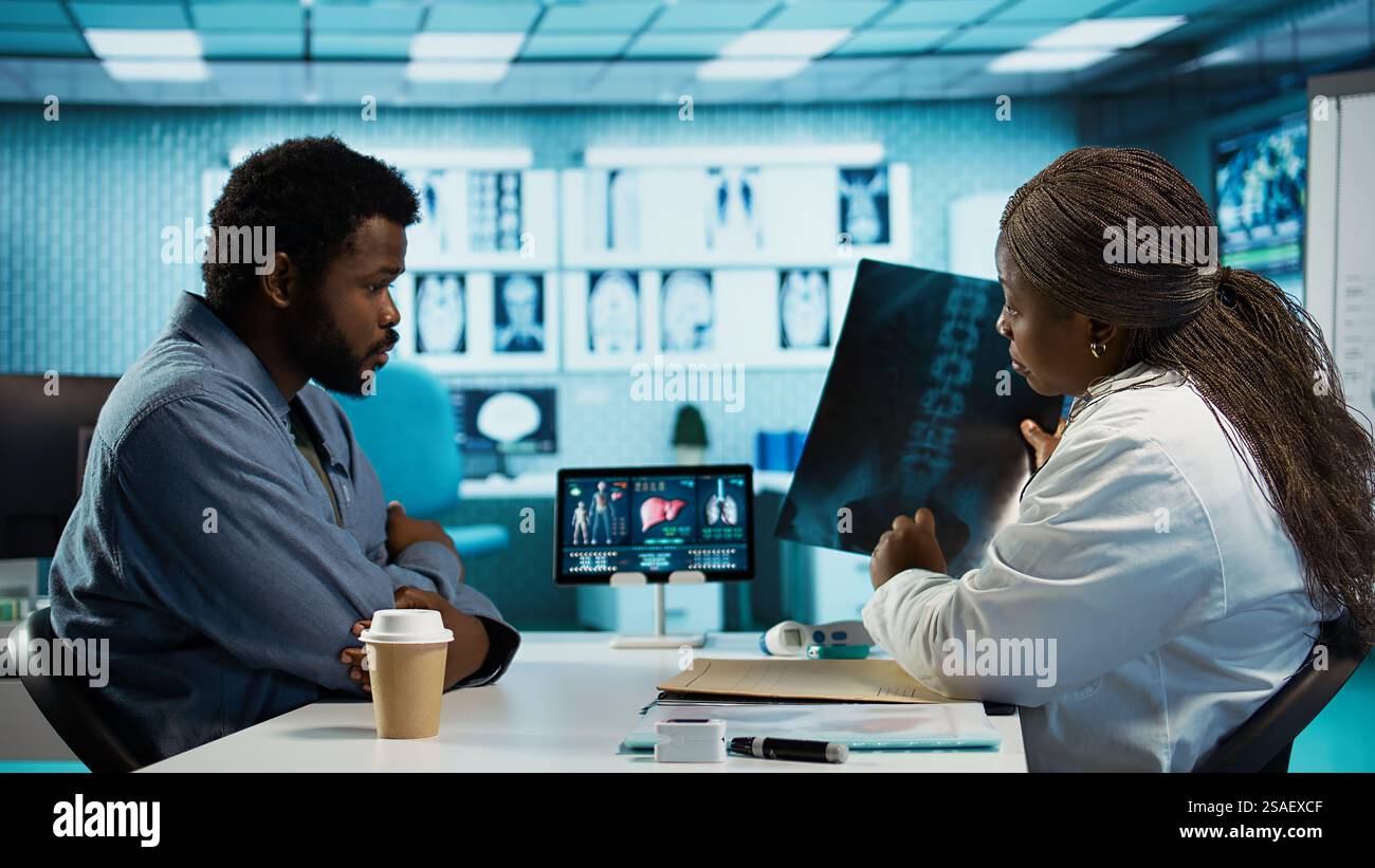 Black male patient bringing x ray test results to medic for scan ...