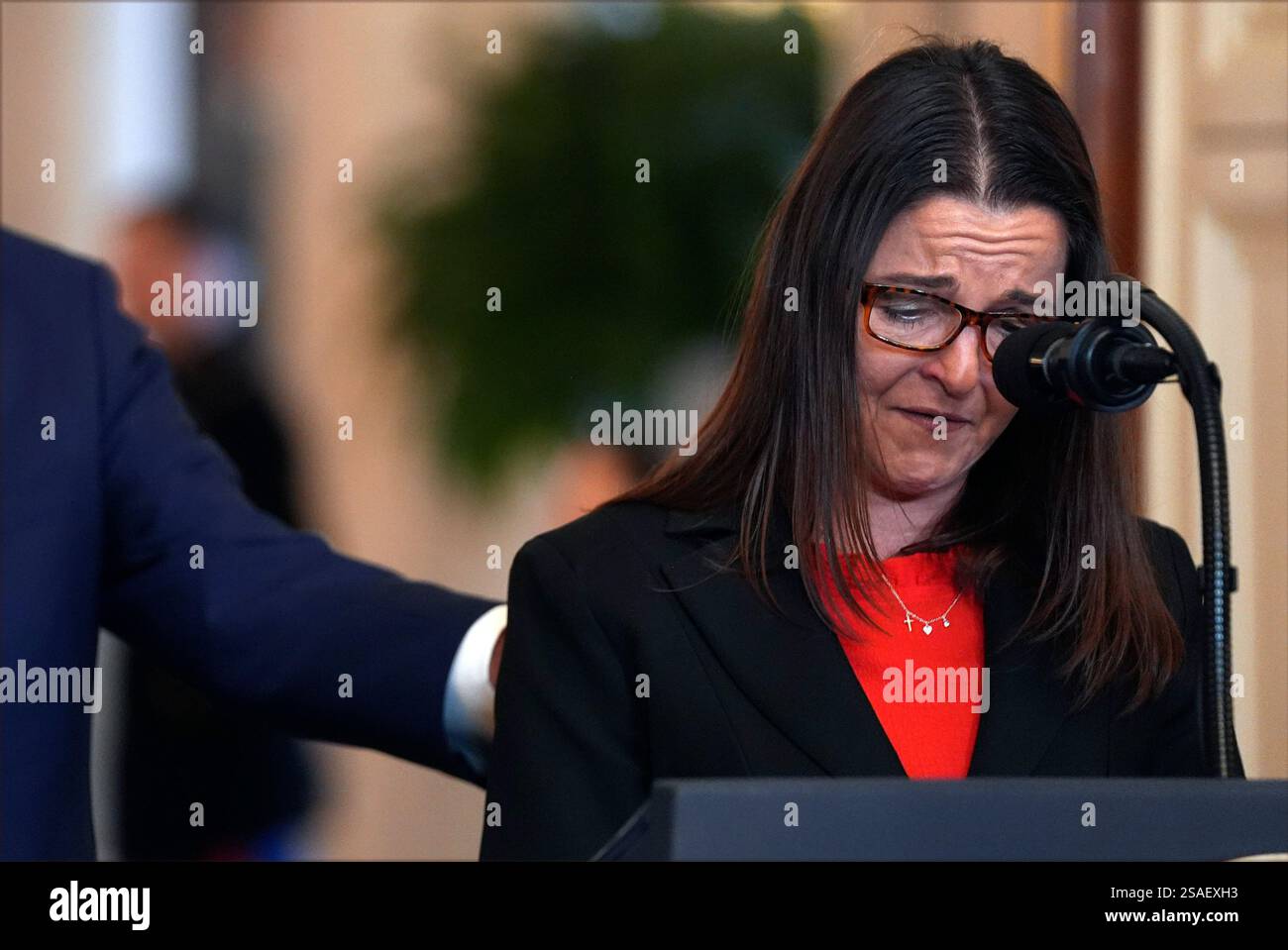 President Donald Trump places his hand on the back of Allyson Phillips ...