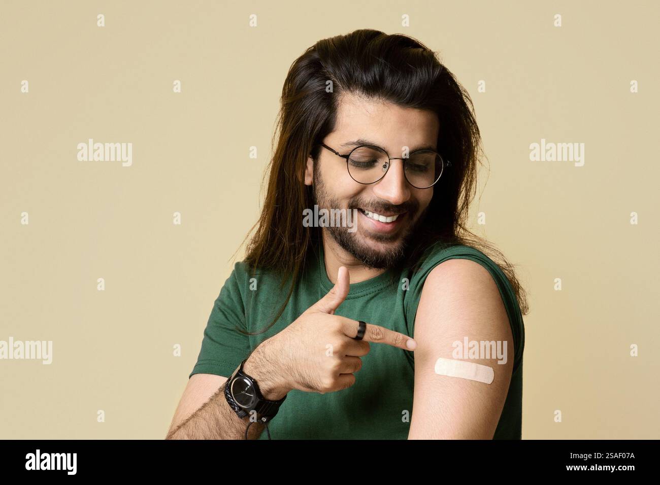 Positive arab guy pointing at plaster on his shoulder Stock Photo - Alamy