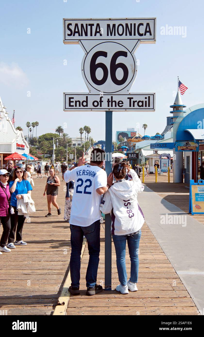 Visitors posing with sing commemorating the historic Route 66 End of ...