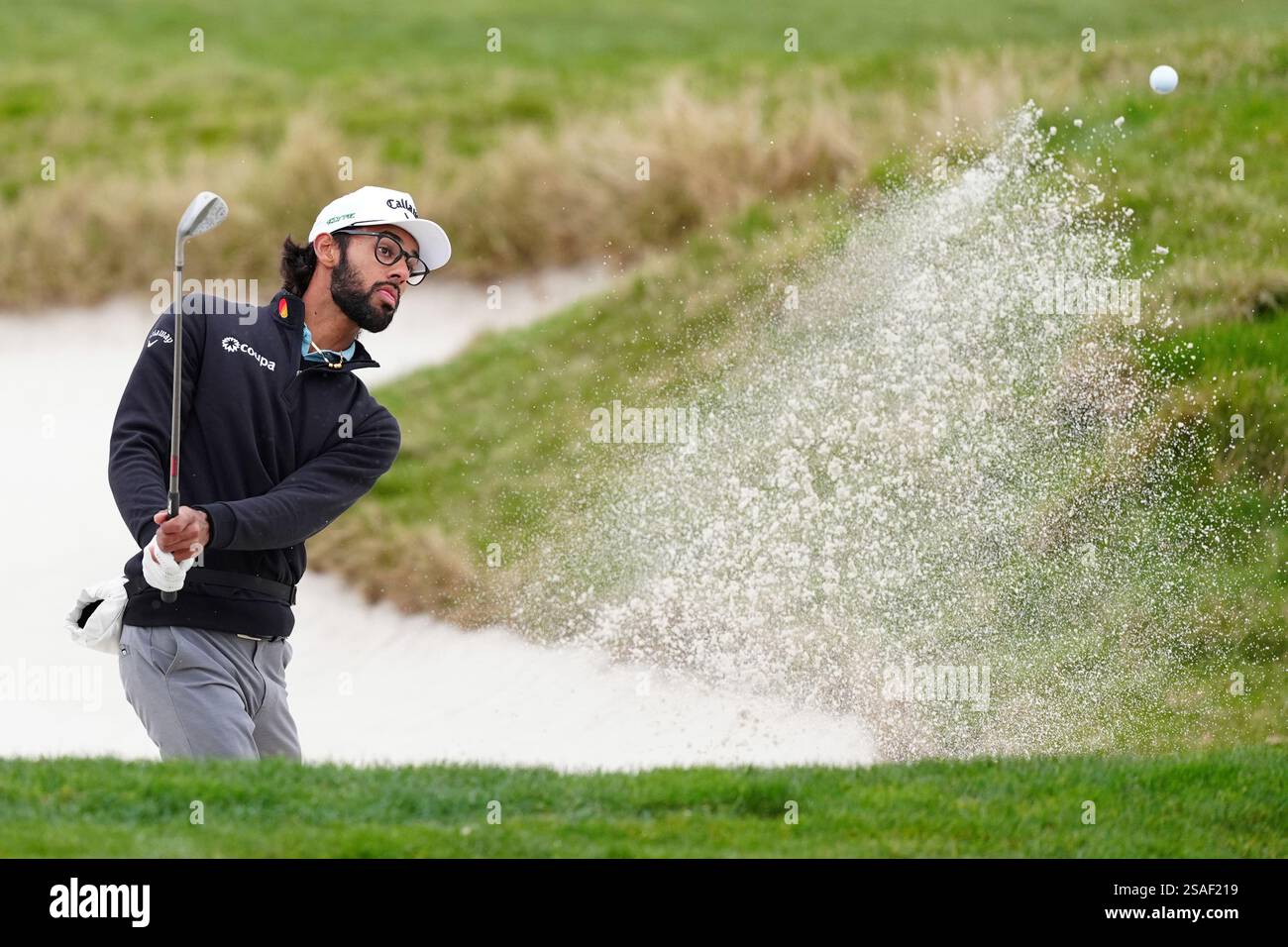 PEBBLE BEACH, CA - JANUARY 29: PGA golfer Akshay Bhatia hits a shot out of the sand on the 17th ...