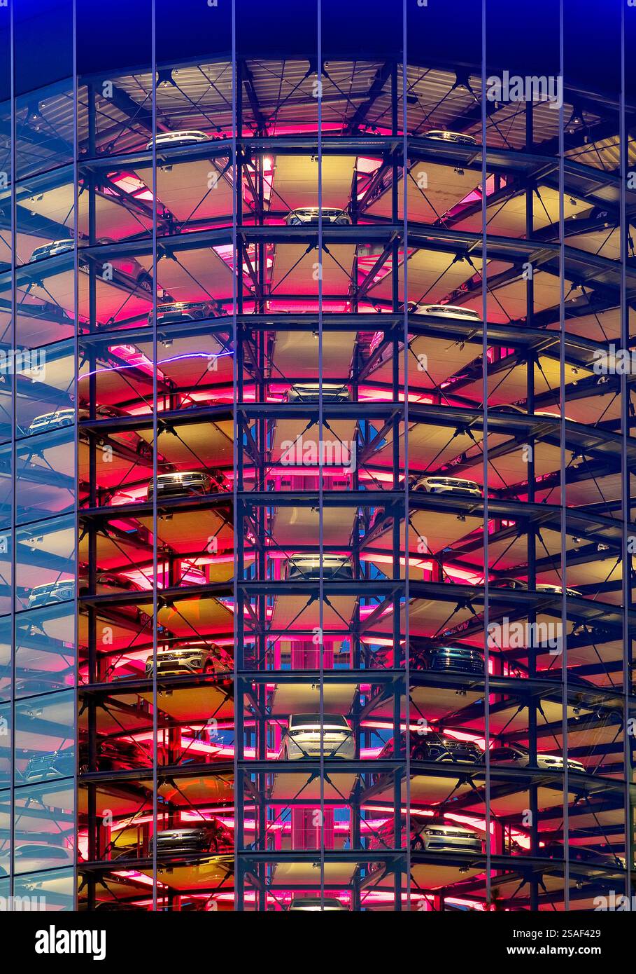 illuminated glass car silo with new cars in the evening, section ...
