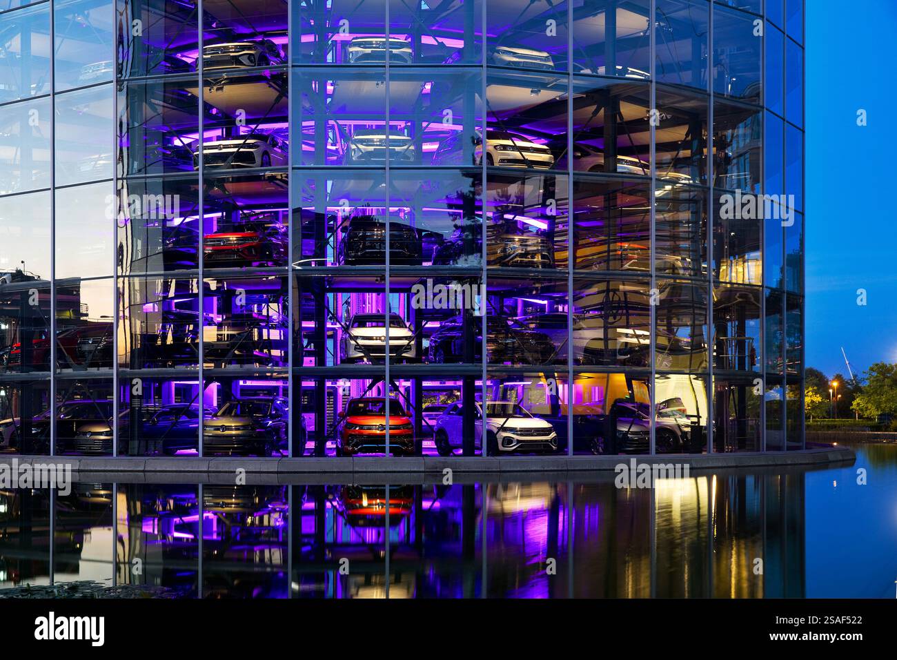 illuminated glass car silo with new cars in the evening, section ...