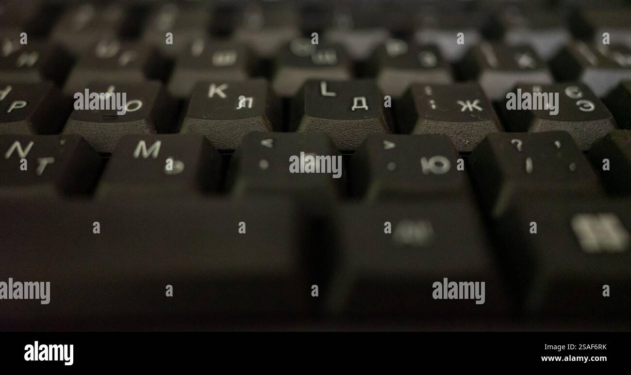 A close-up view of a keyboard highlighting Cyrillic characters ...