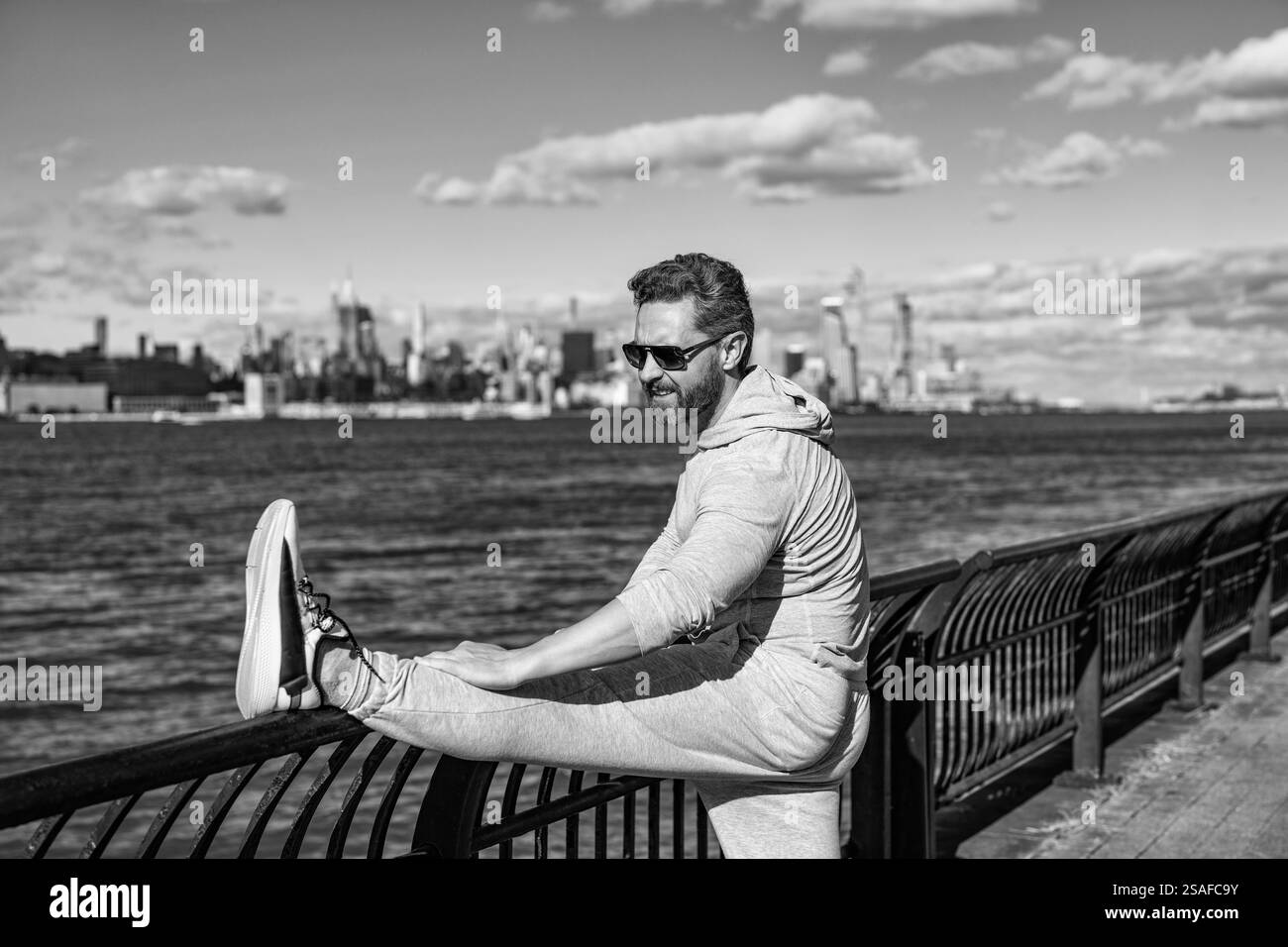 Sportsman stretching his muscles after running. Sportsman improve ...