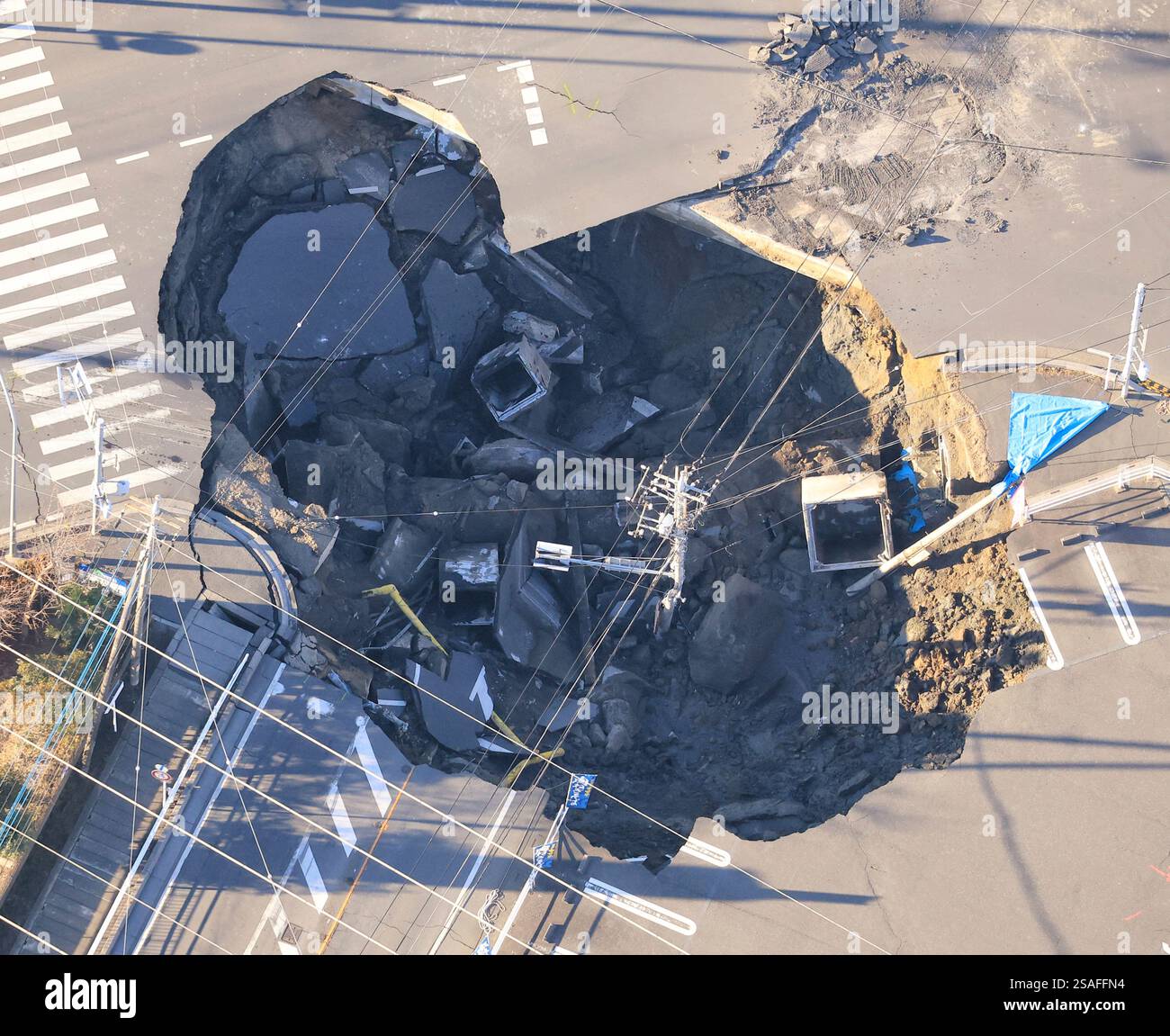 An aerial photo shows sinkholes at an intersection in Yashio City ...