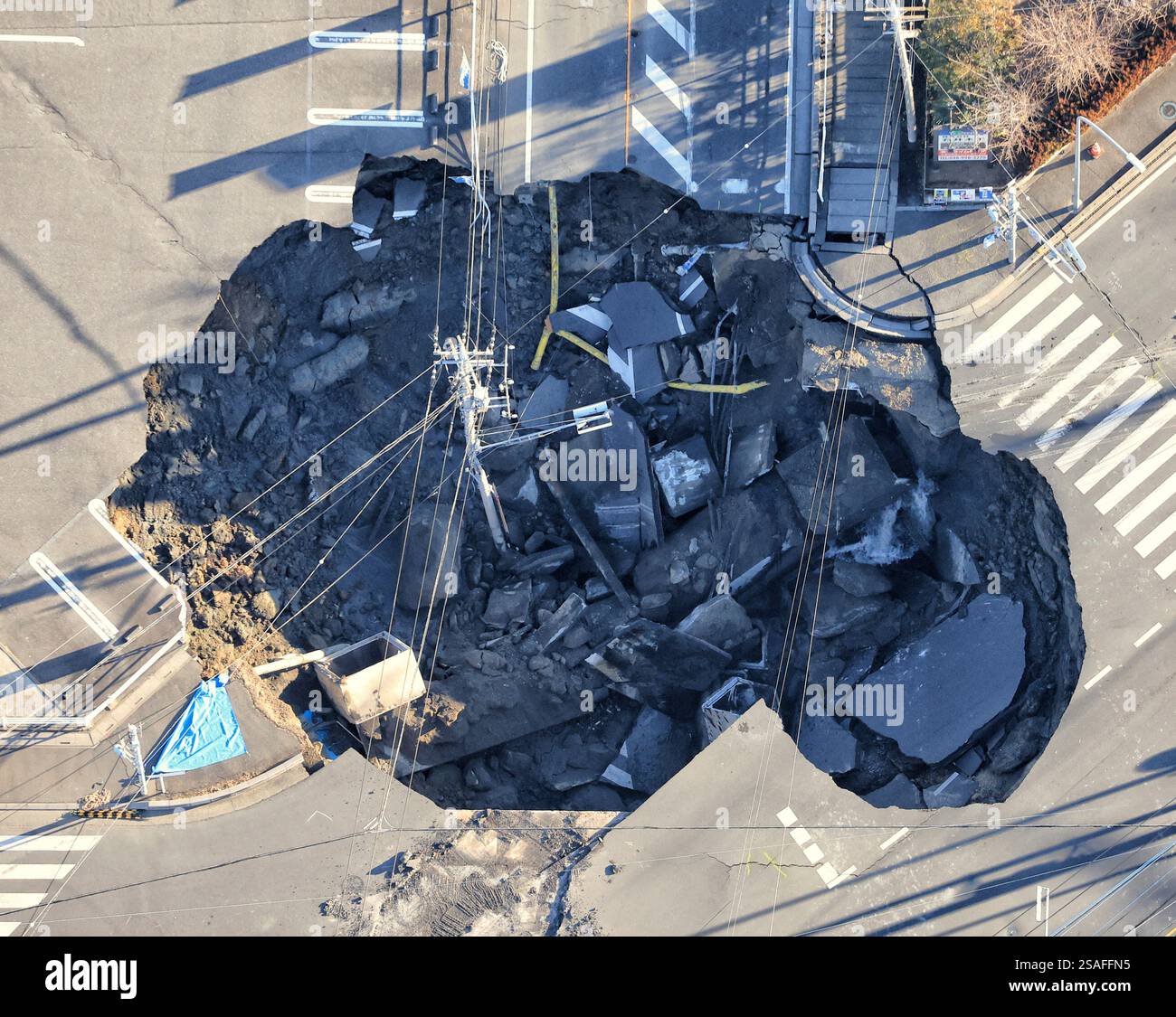 An aerial photo shows sinkholes at an intersection in Yashio City ...