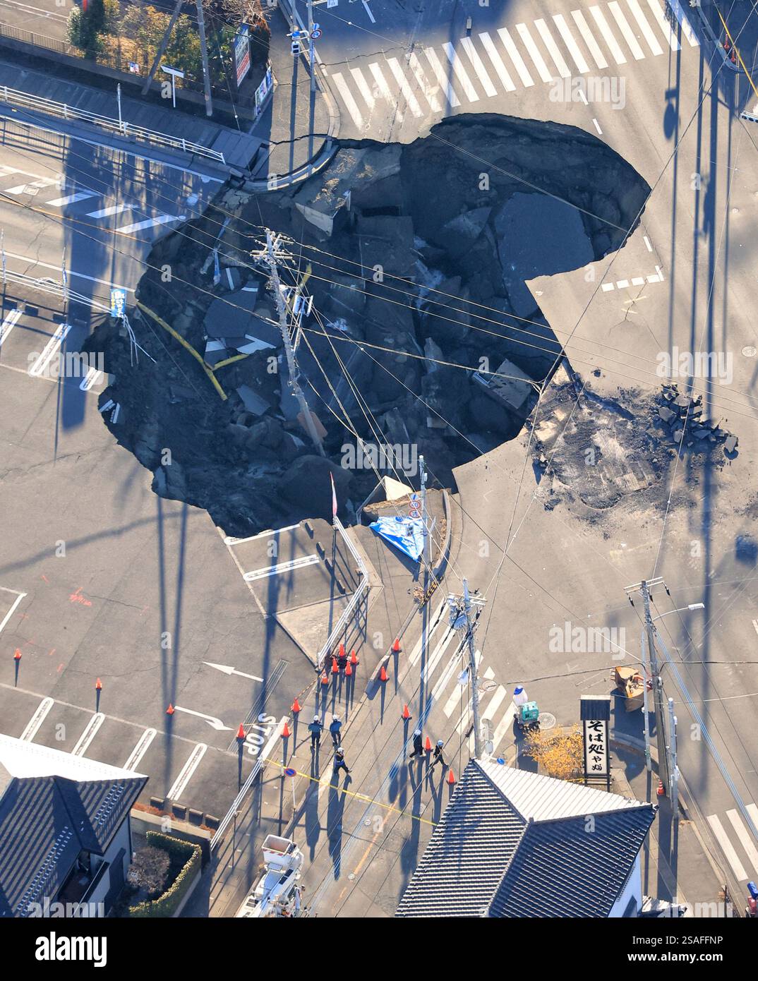 An aerial photo shows sinkholes at an intersection in Yashio City ...