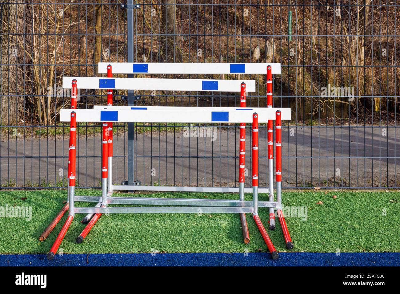 Athletics hurdles near the stadium fence. Steeplechase. Red and white ...