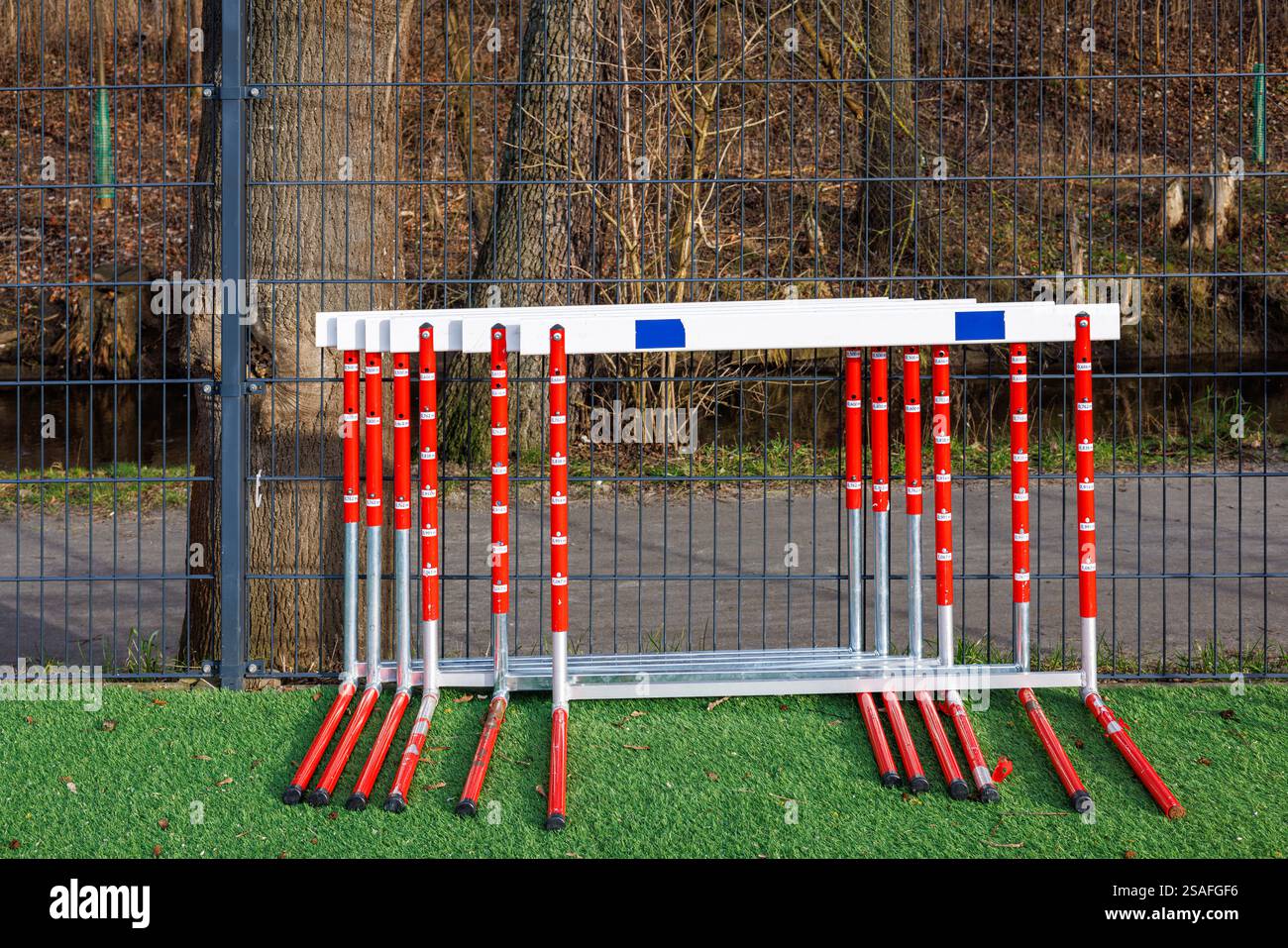 Six athletics hurdles at the city stadium. Red and white hurdles near ...