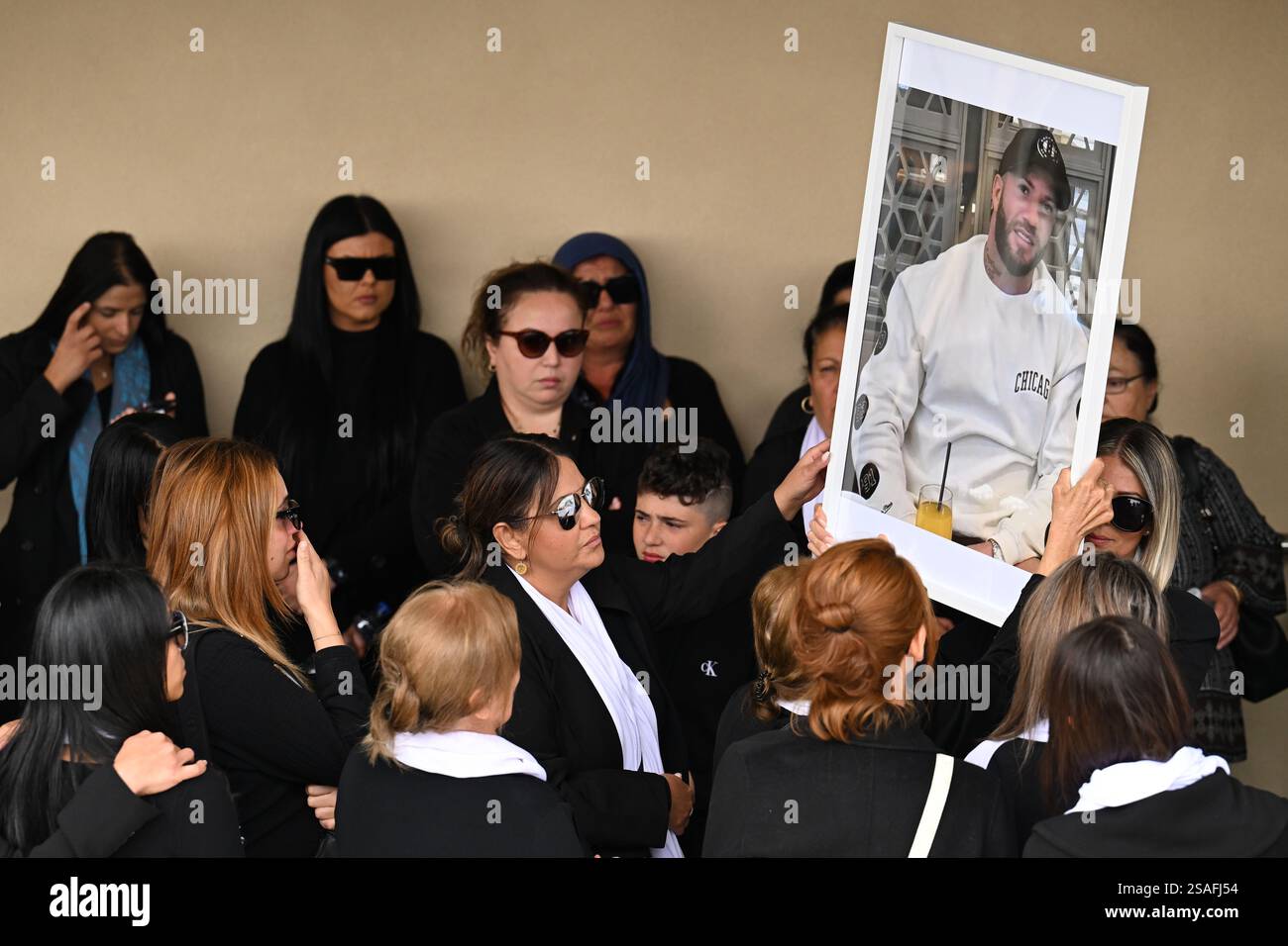 Melbourne, Australia. 30th Jan, 2025. Mourners gather around a framed ...