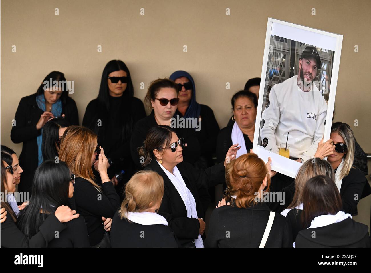 Melbourne, Australia. 30th Jan, 2025. Mourners gather around a framed ...