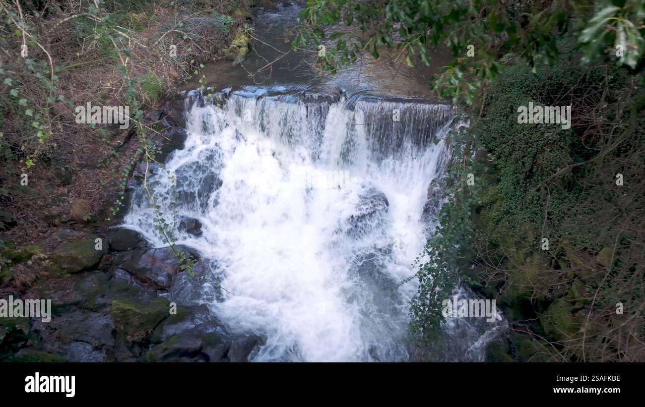 A powerful waterfall cascades over a man-made structure near Cascata do ...