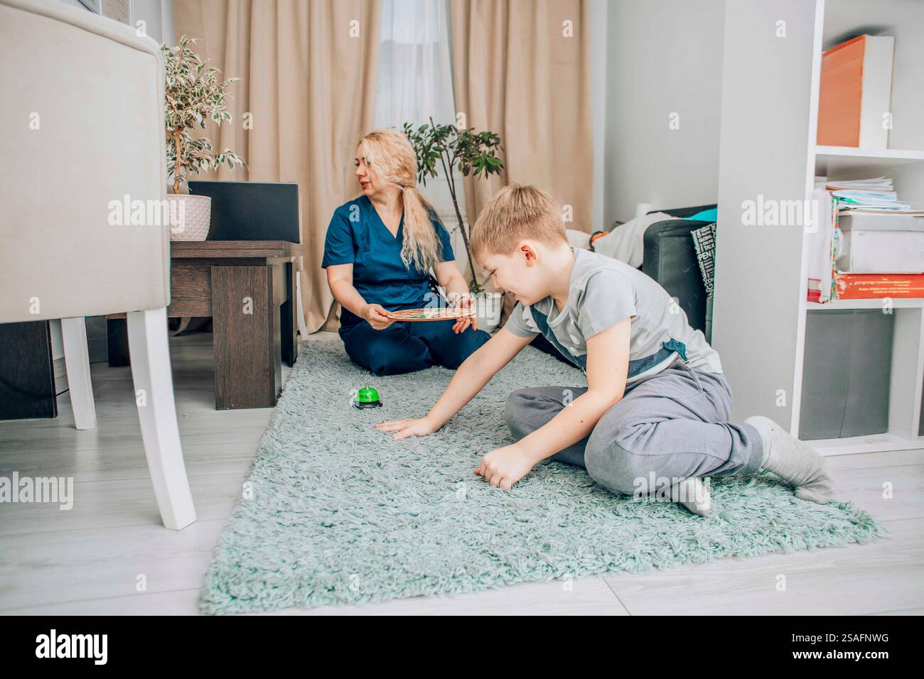 Therapist guiding a child in an interactive educational activity on the ...