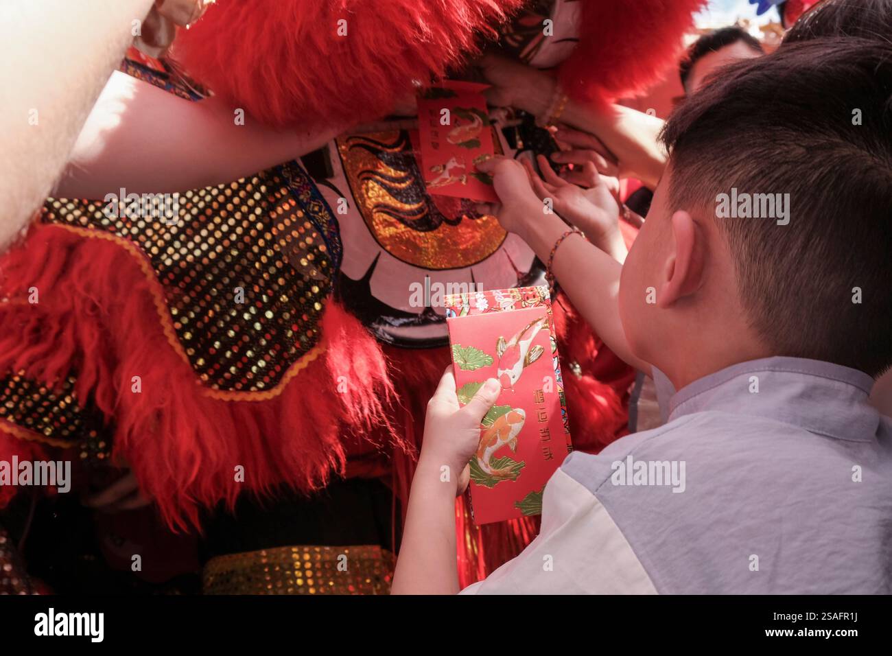 A little boy seen giving angpao for lion dance performance during the ...