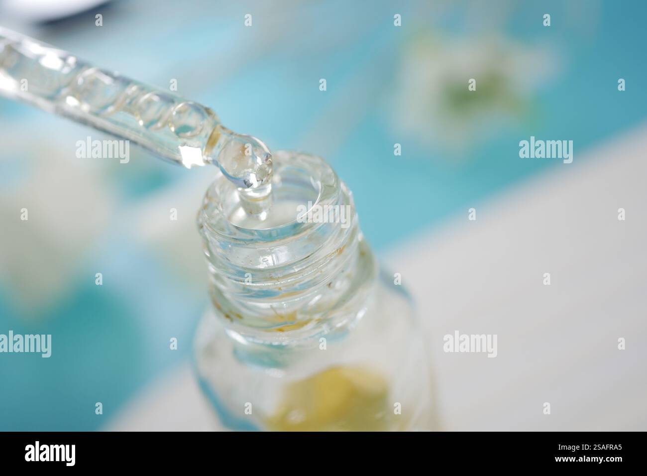 Clear dropper releases liquid from a glass container Stock Photo - Alamy