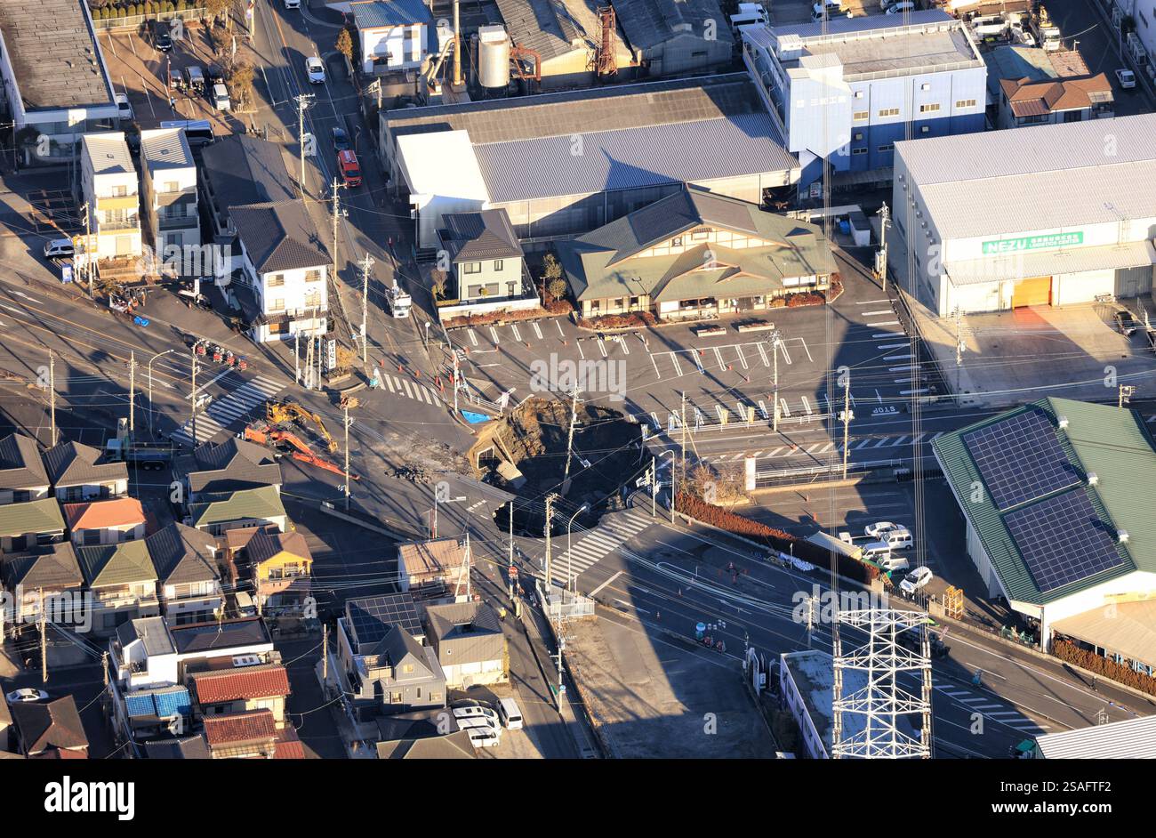 An aerial photo shows sinkholes at an intersection in Yashio City ...
