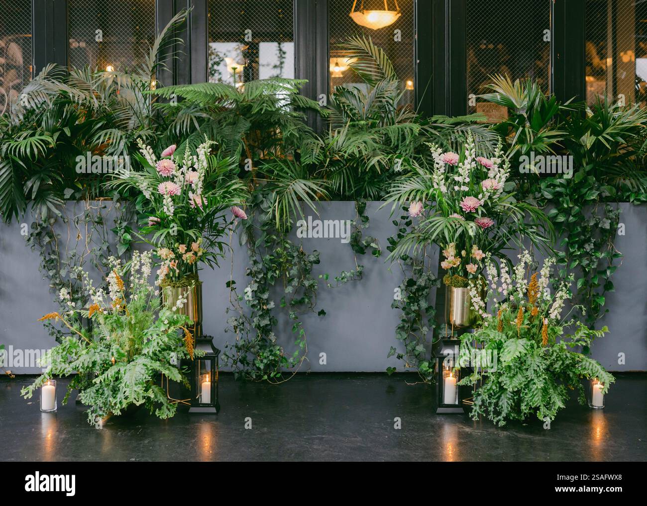 Lush floral arrangements featuring greenery and pink flowers decorate a ...