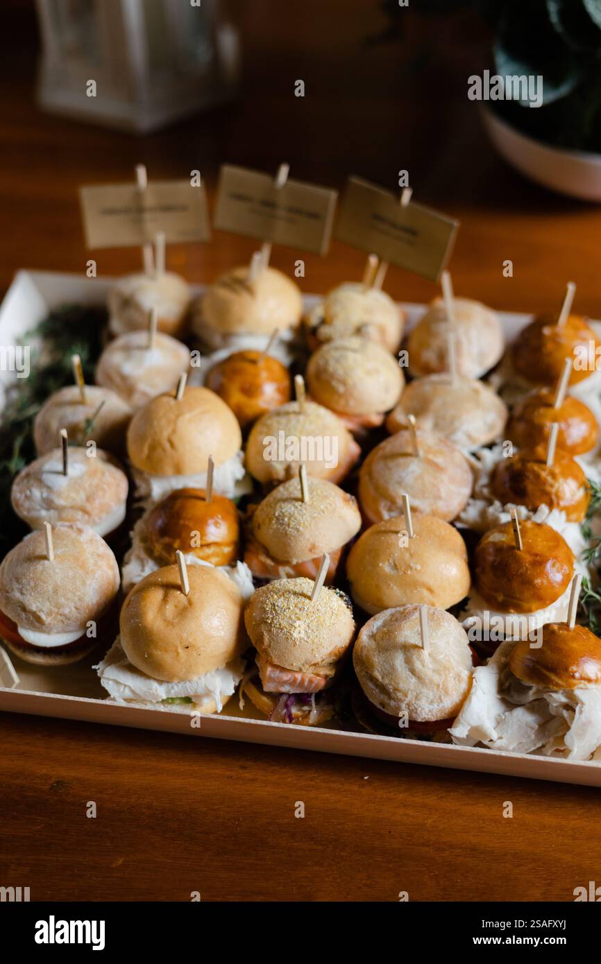 A vibrant assortment of mini sandwiches is displayed on a tray on a ...