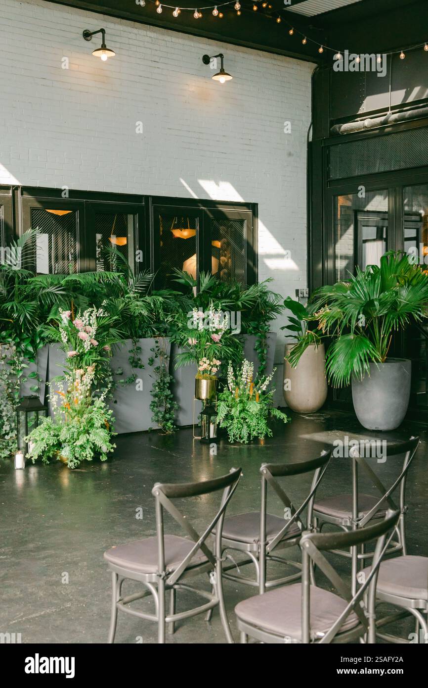 An inviting event space showcases lush plants and elegant seating ...