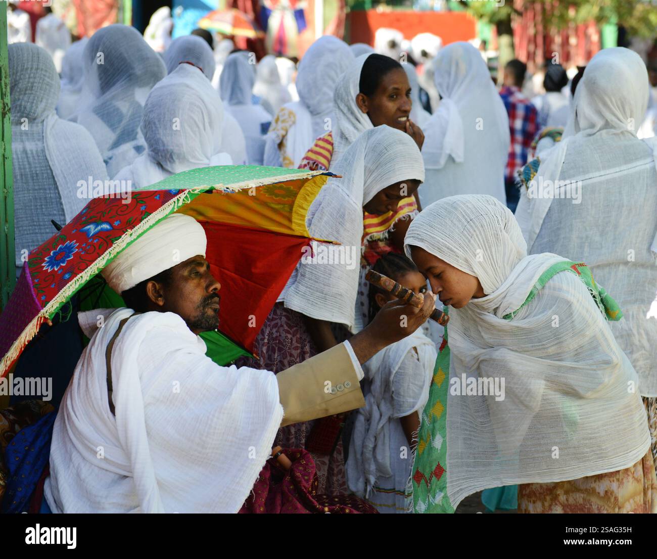 An Ethiopian Orthodox priest blessing worshippers at a local church ...
