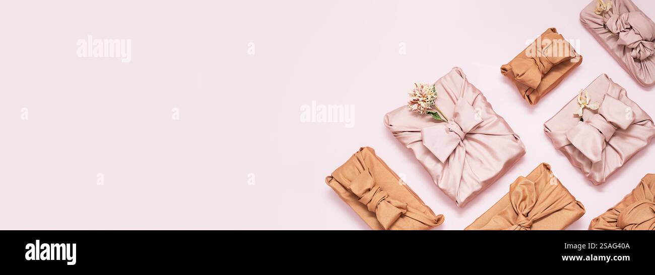 Presents wrapped in fabric scatted on pink Stock Photo - Alamy