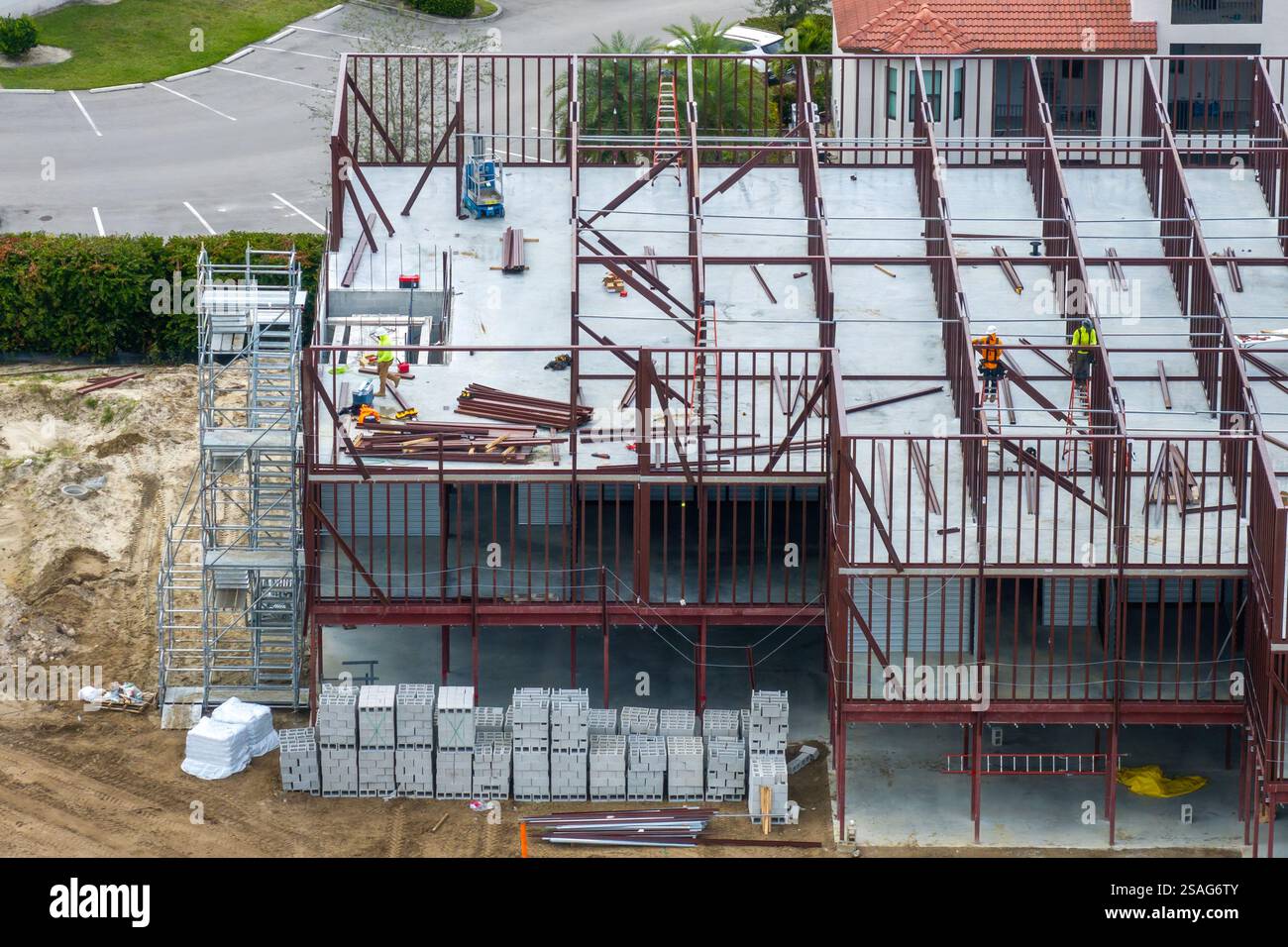 Construction works on metal walls of commercial building. Blue collar ...